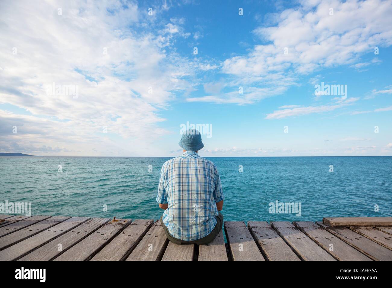 Man relaxing on sea pier Stock Photo - Alamy
