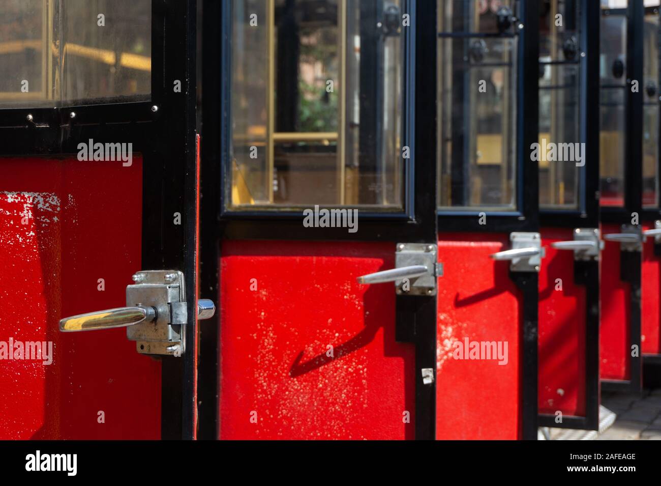 Row of open red and black doors on a sightseeing tram Stock Photo - Alamy