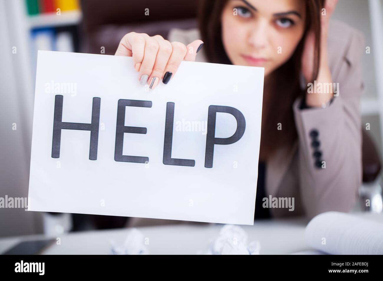 Stressed business woman imploring for help, holding a cardboard with ...