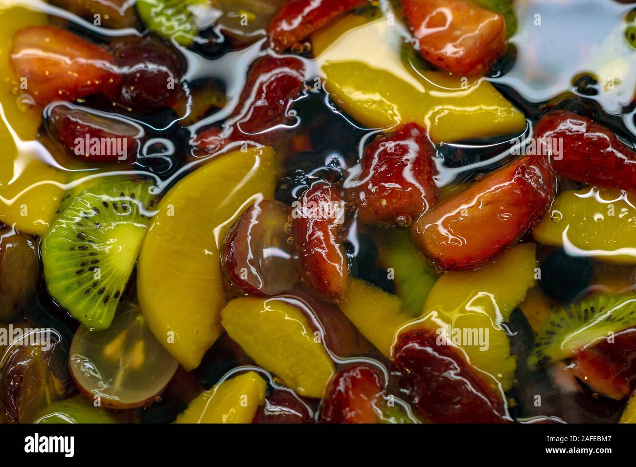 Multi-colored jelly with slices of natural fruits. Close up. View from ...