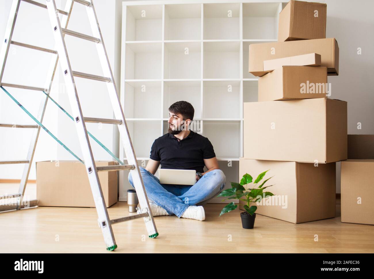 Happy young man moving to new home - having fun Stock Photo - Alamy