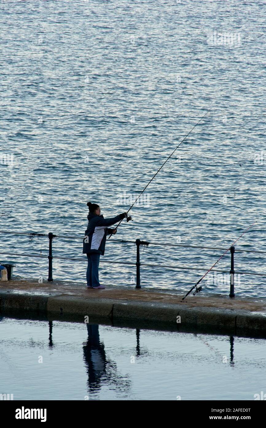 Angler fishing from outdoor sea water swimming pool Stock Photo - Alamy
