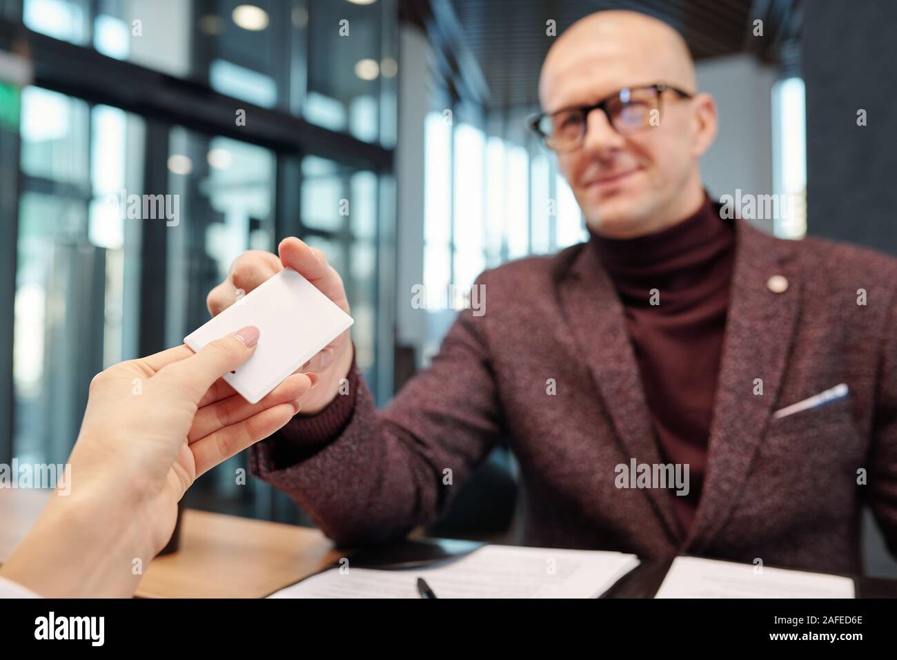 Hand of businessman taking card from empty hotel room at reception ...