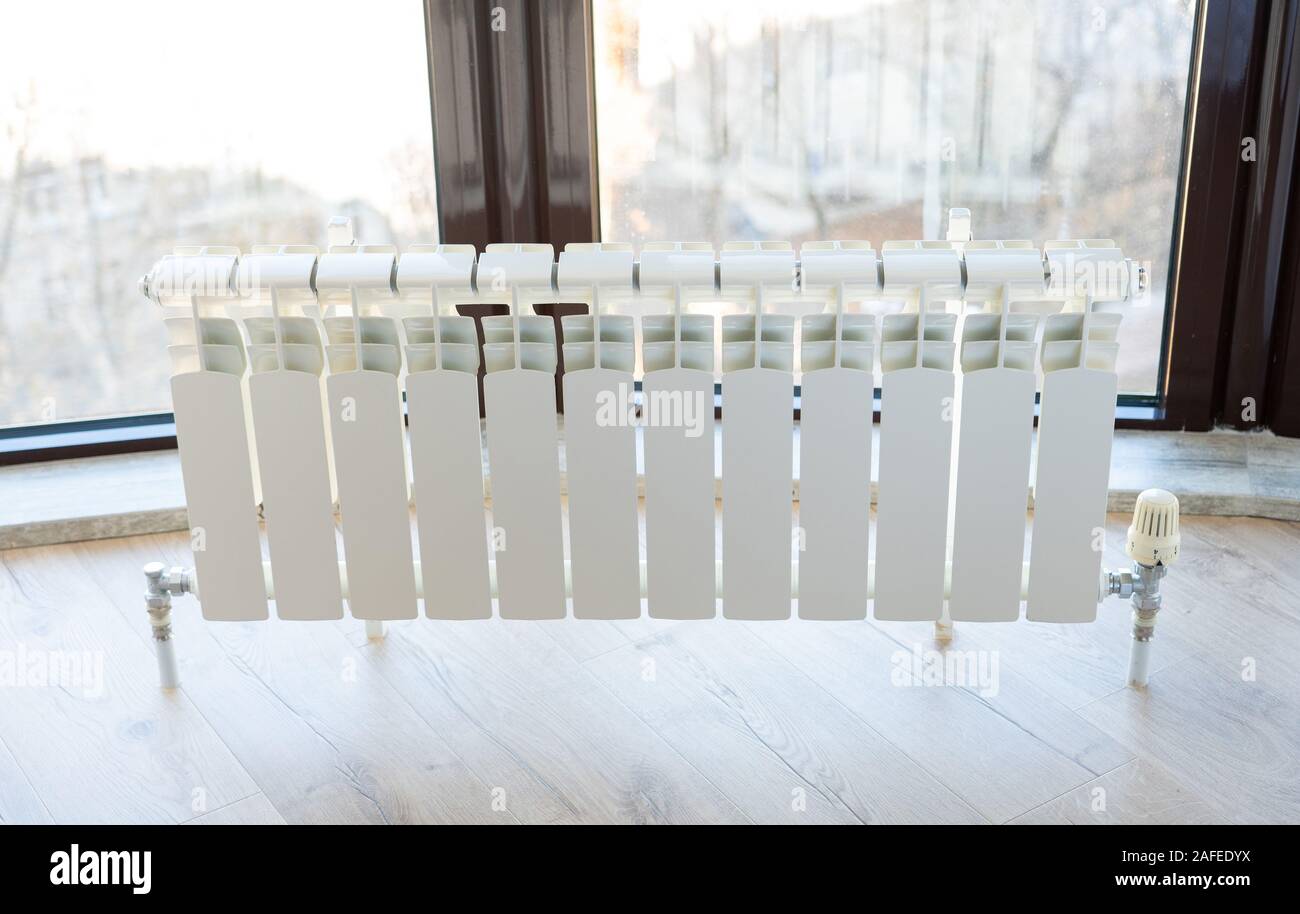 White big radiator near window in a modern room Stock Photo - Alamy
