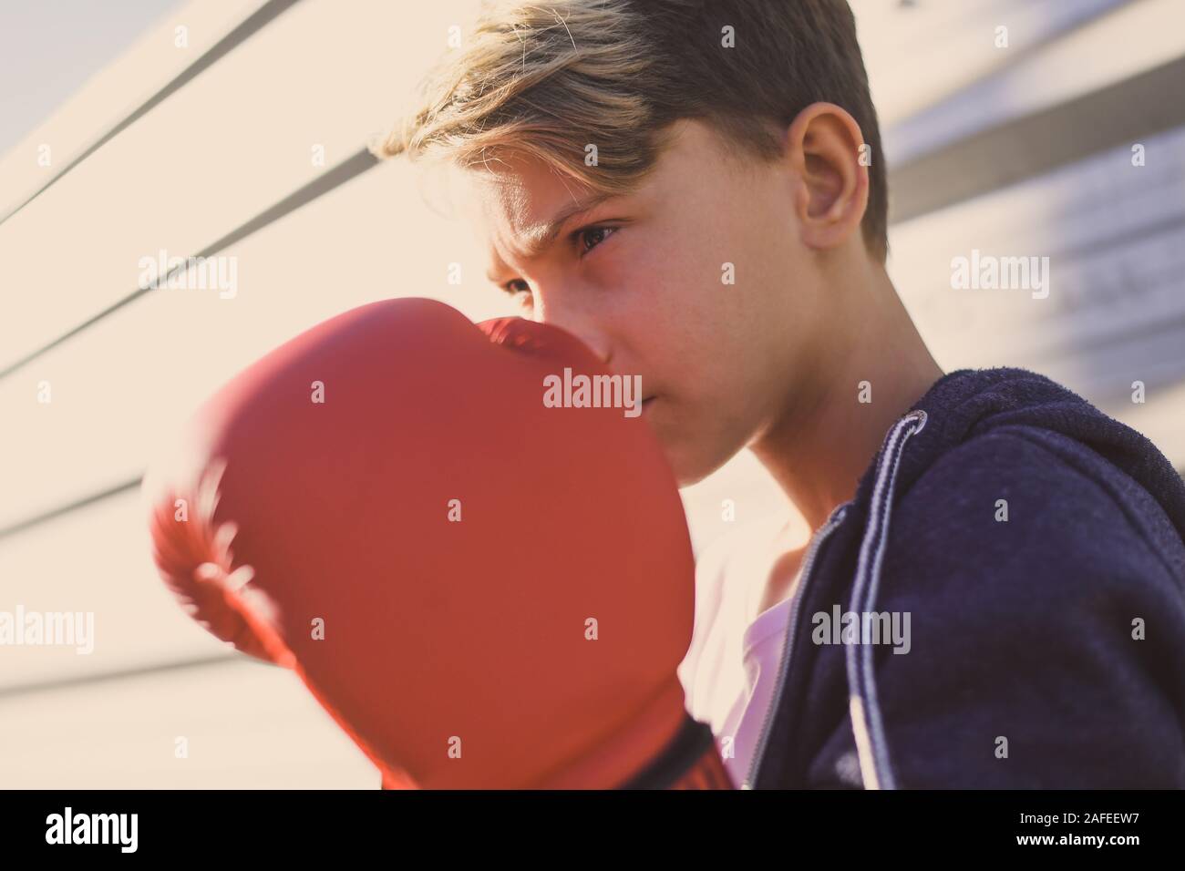 Portrait of handsome young male with boxing gloves ahead the face. Boy ...