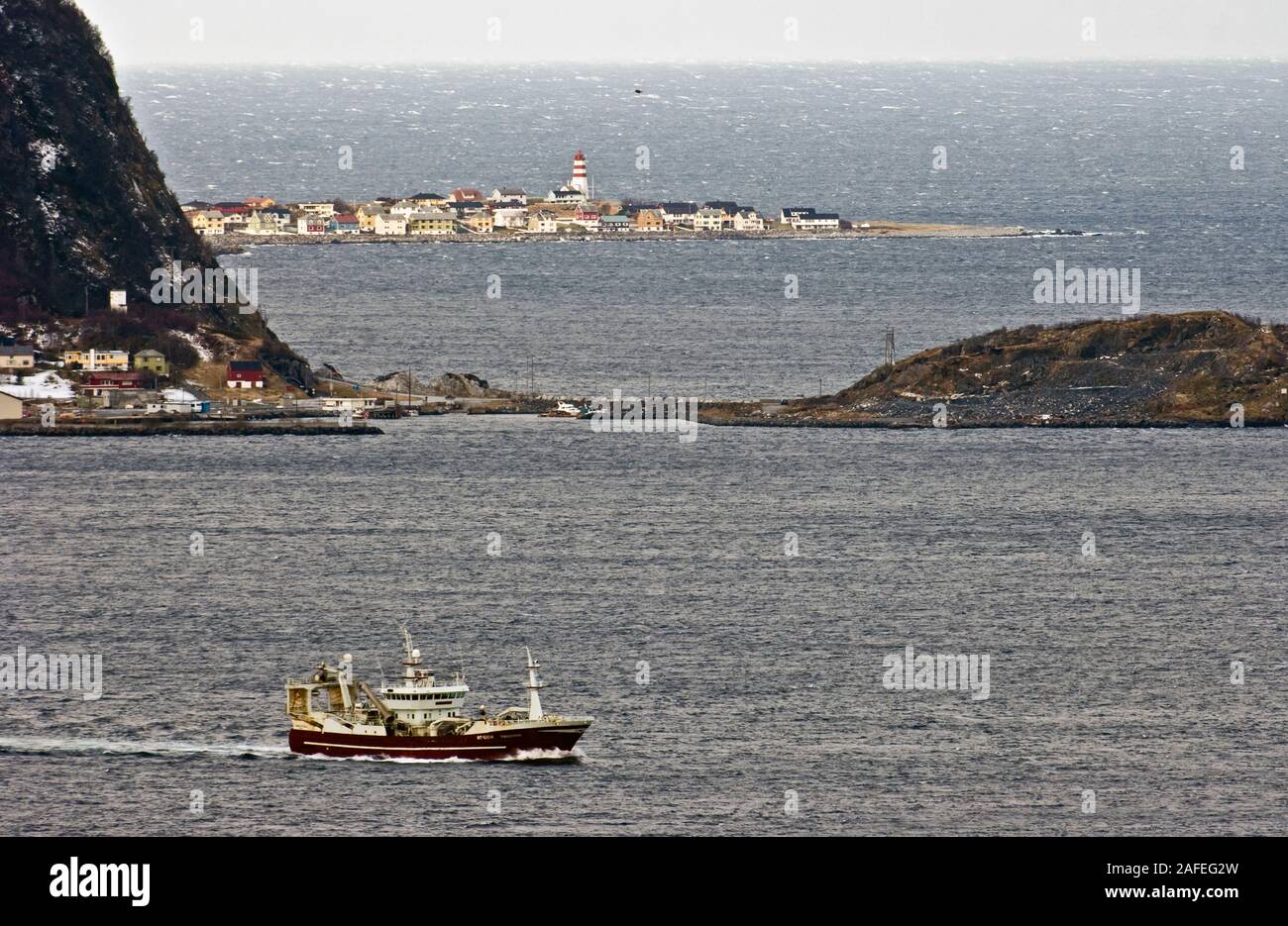 Norwegian trawler off Alnes, a small island with a traditional lifght ...