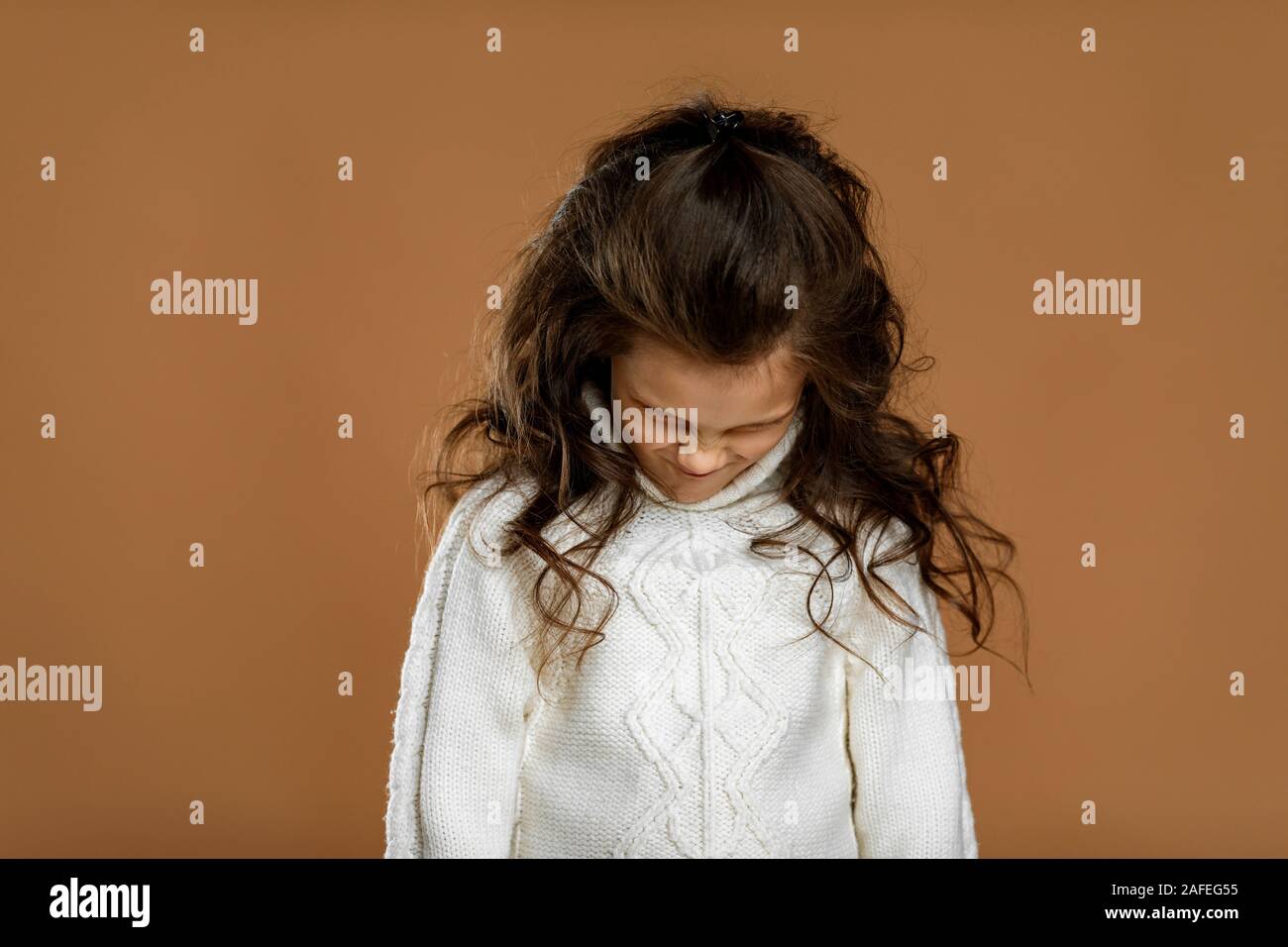 frowned little child girl in white sweater. Human emotions and facial ...