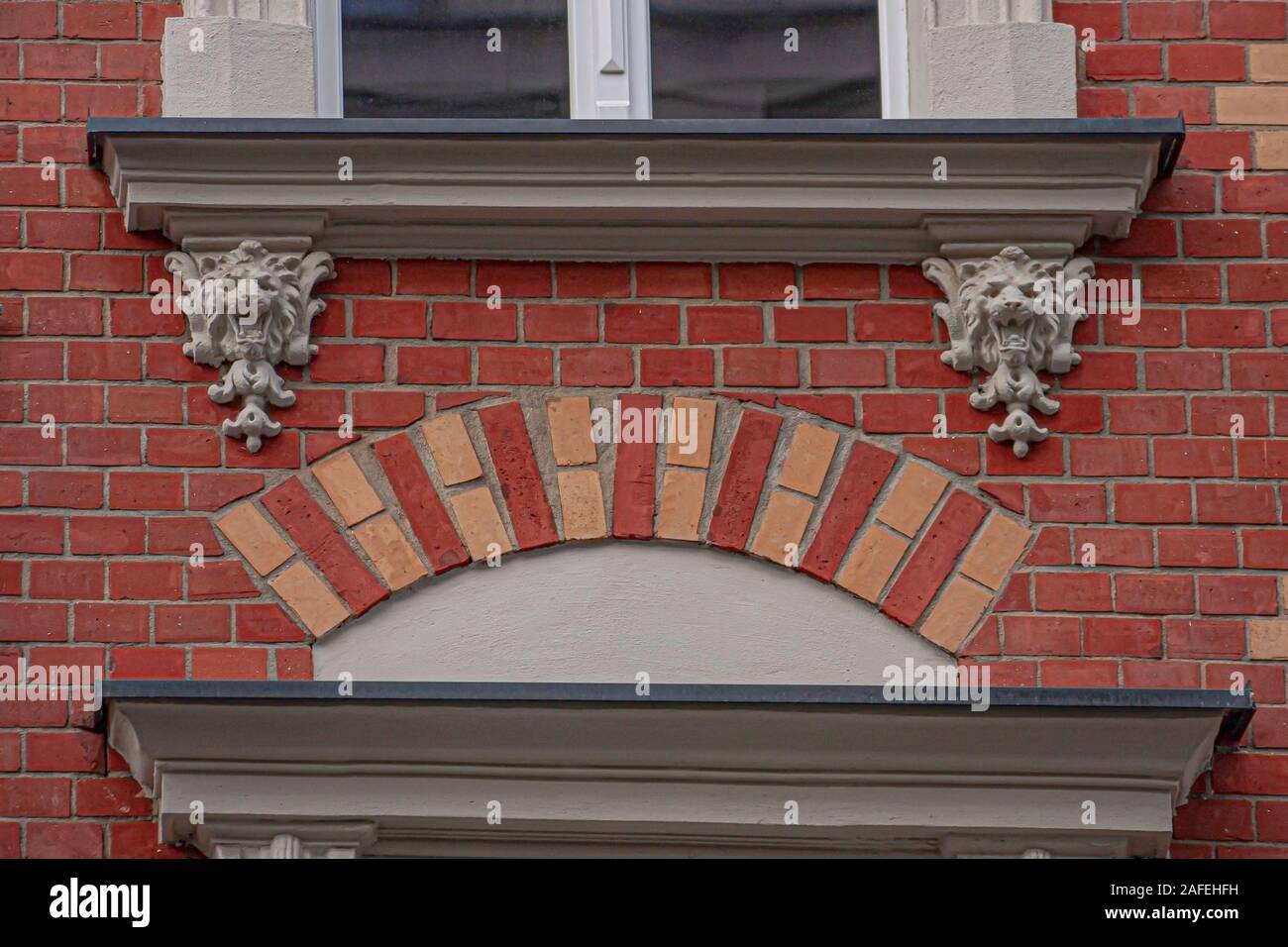 Eclectic tenement house arch doors shell lion head relief old stone red ...