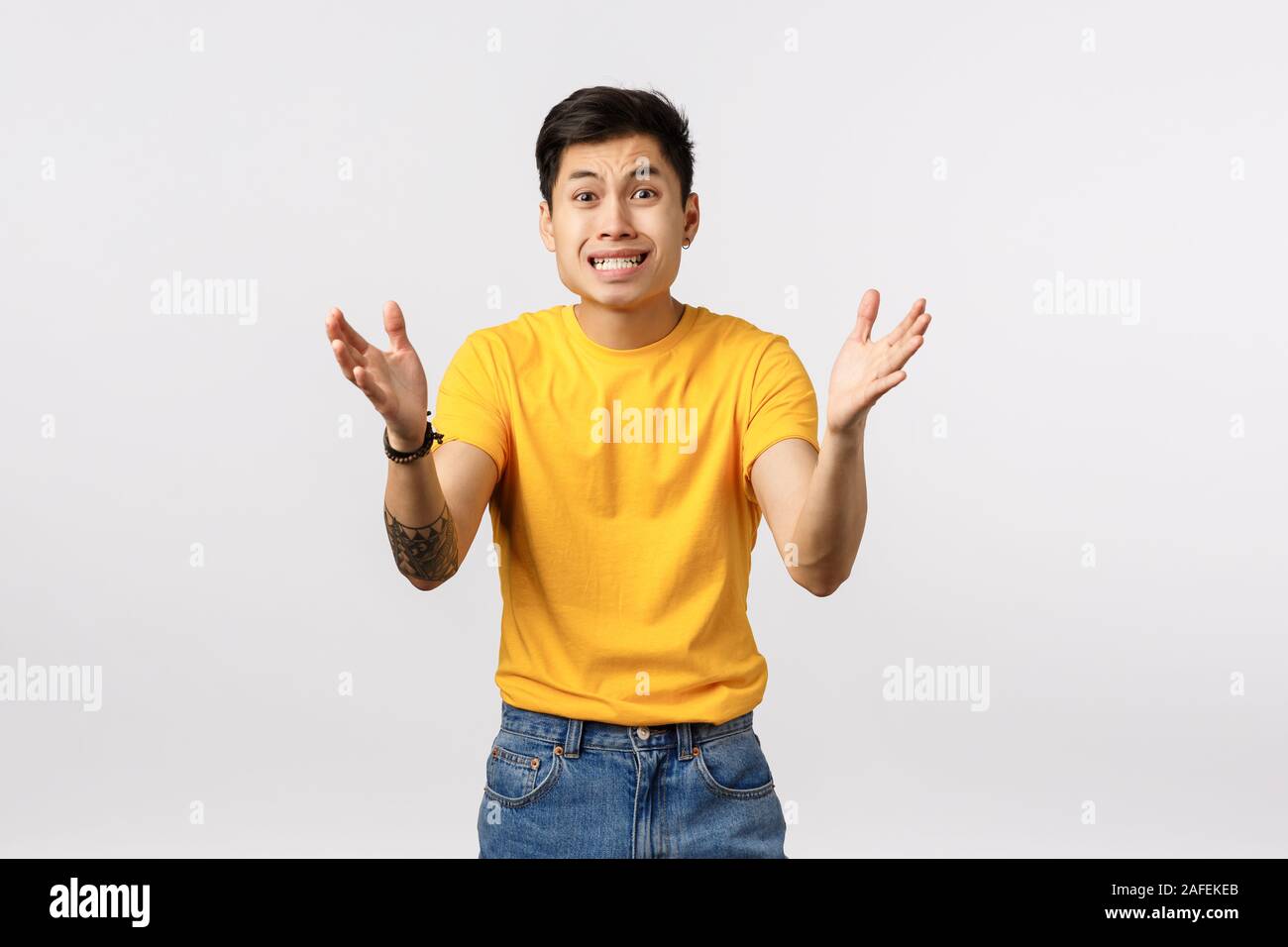 Scared emotional asian young man panic, freak out and anxiously shaking ...