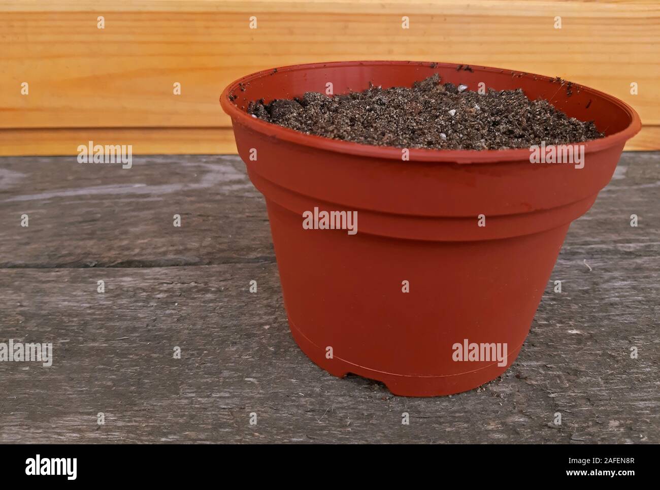 A pot full of potting soil on wooden background Stock Photo - Alamy