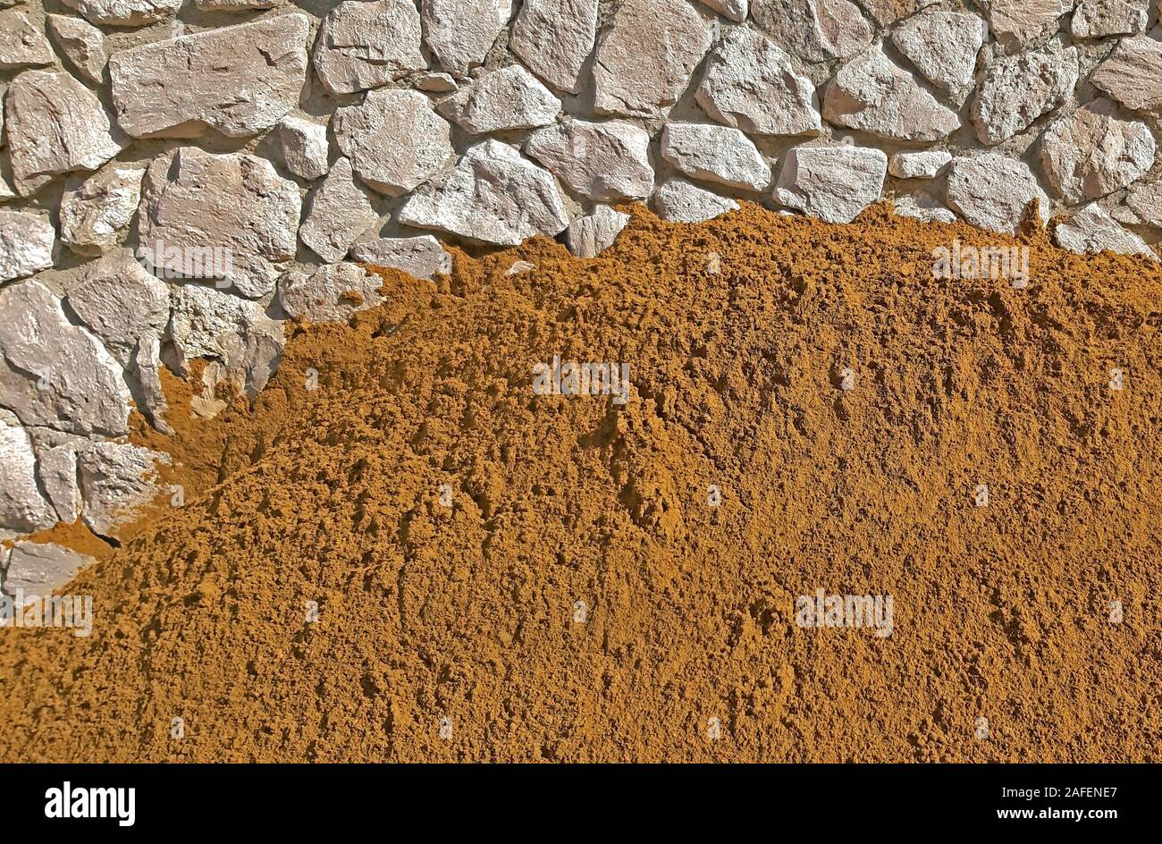 A lot of Construction sand near a wall background Stock Photo - Alamy