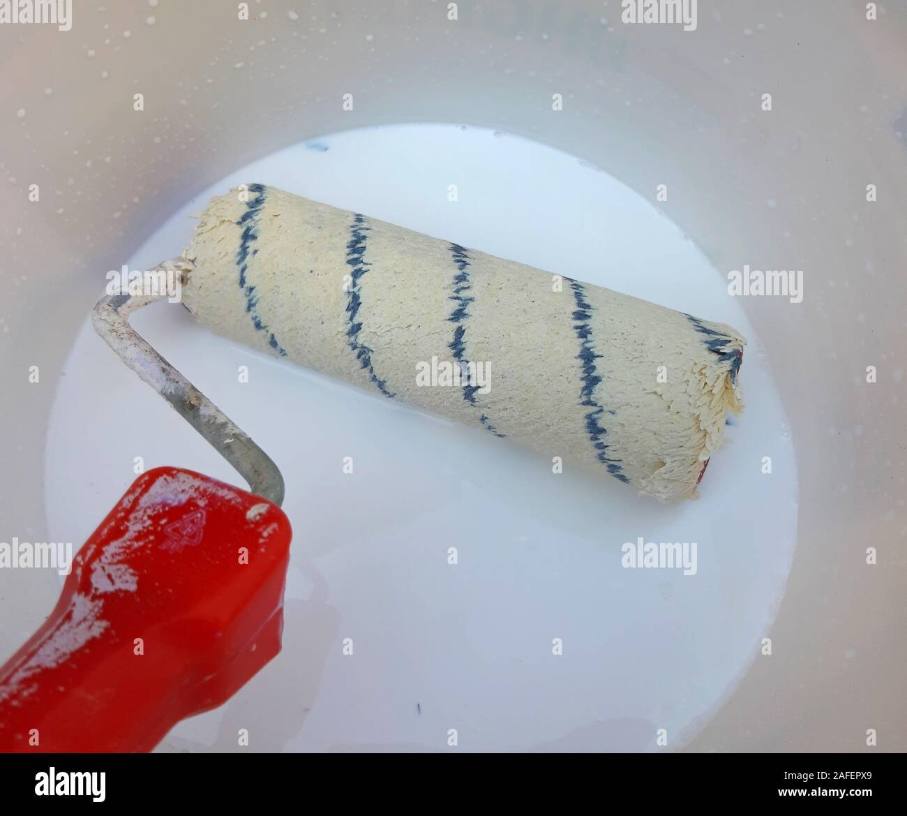 White primer paint roller in the bucket Stock Photo - Alamy