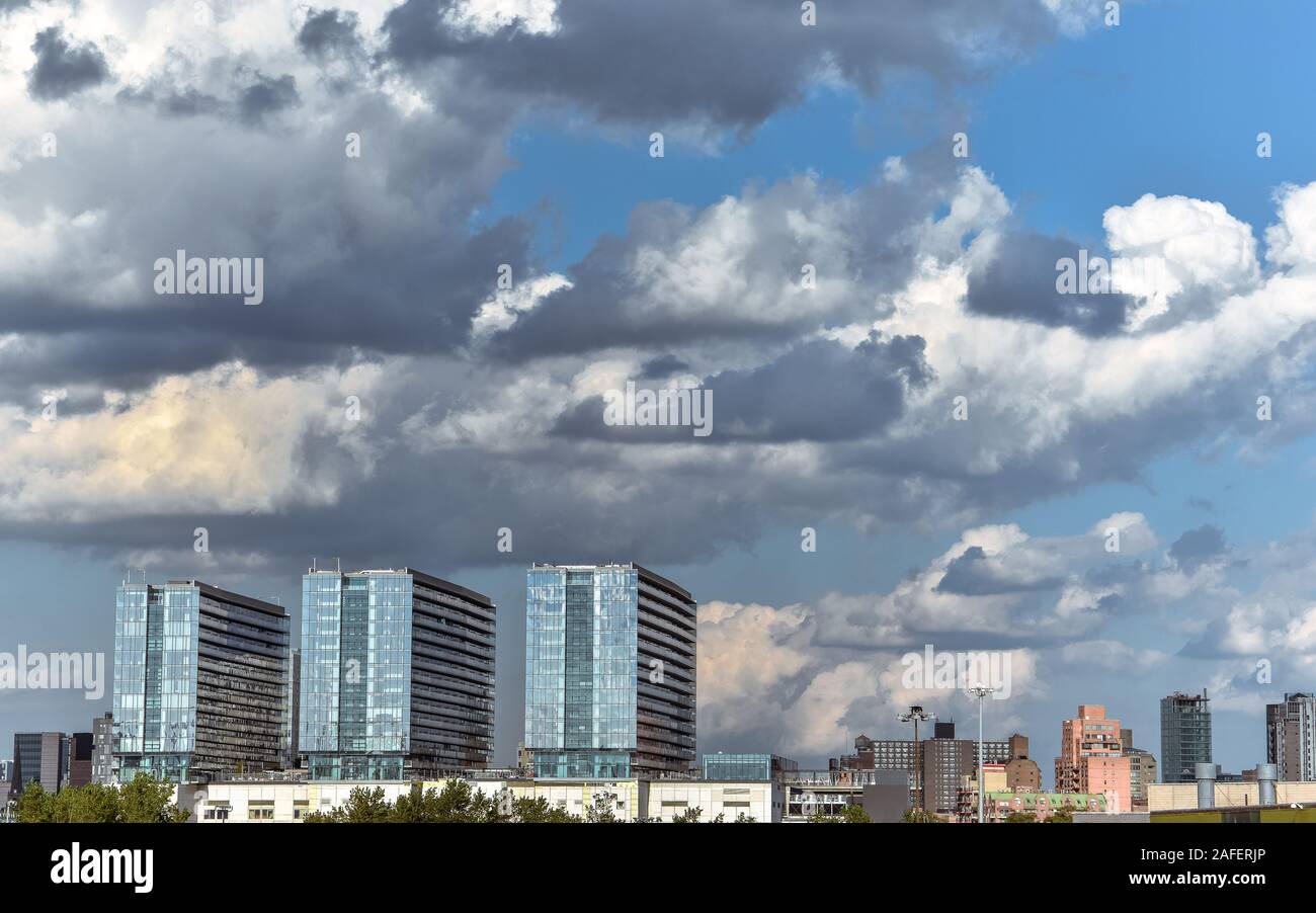Generic city view with cloudy blue sky. Row of three main buildings in ...
