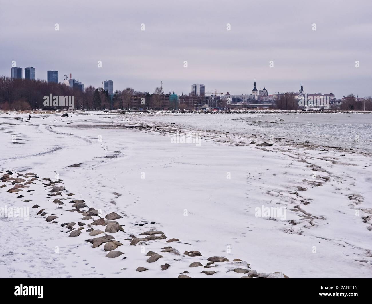 Beach with snow, the frozen baltic sea and the skyline of Tallinn Stock ...
