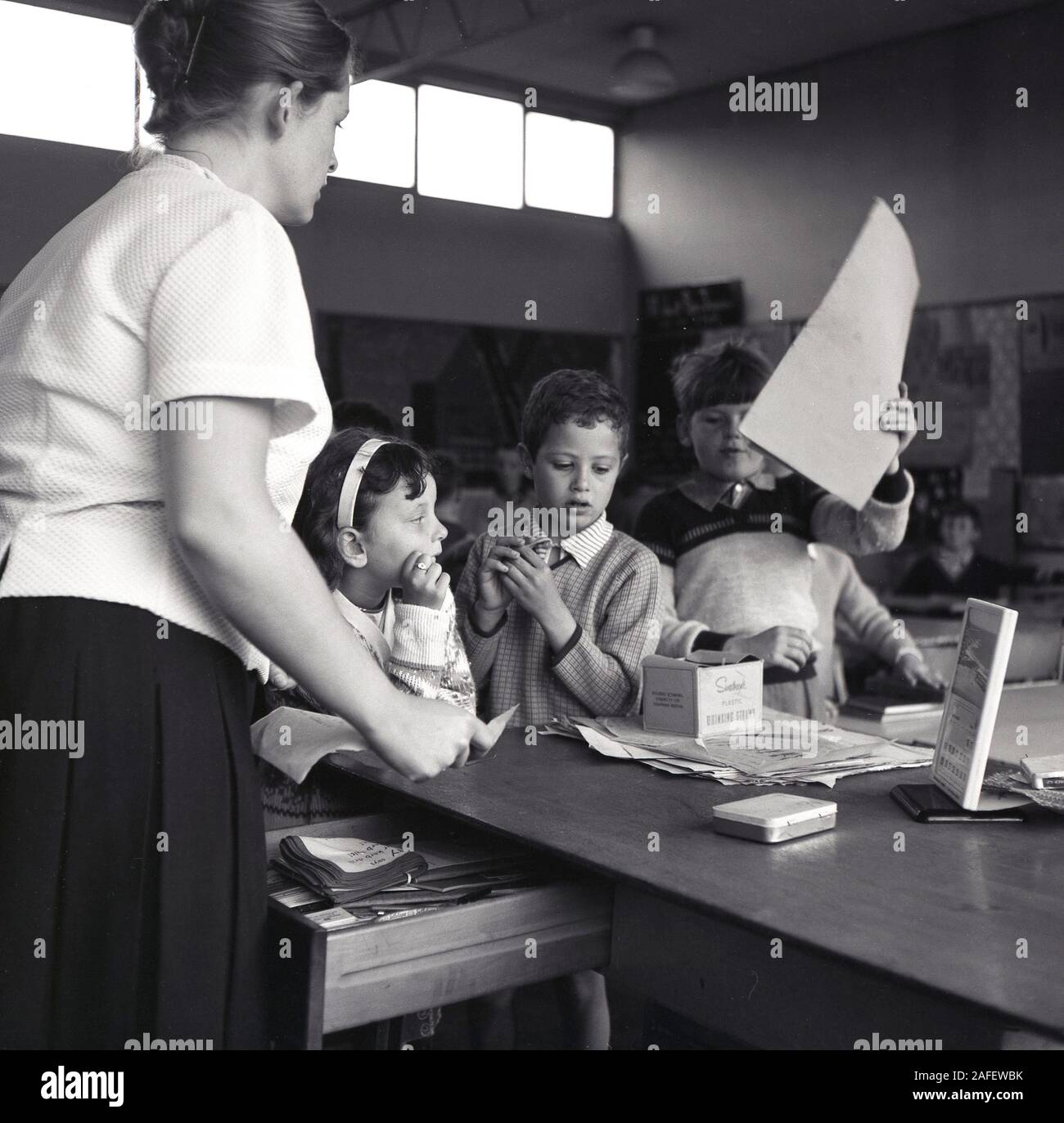 1960s, historical, a female primary school teacher with children in the ...