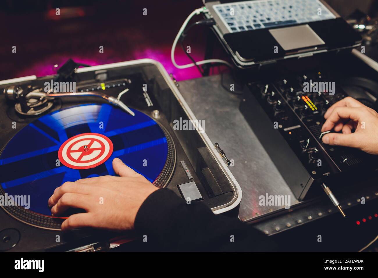 Dj hands on equipment deck and mixer with vinyl record at party Stock ...