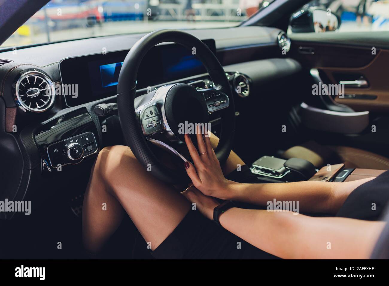 Long female legs on a steering wheel of a car Stock Photo - Alamy