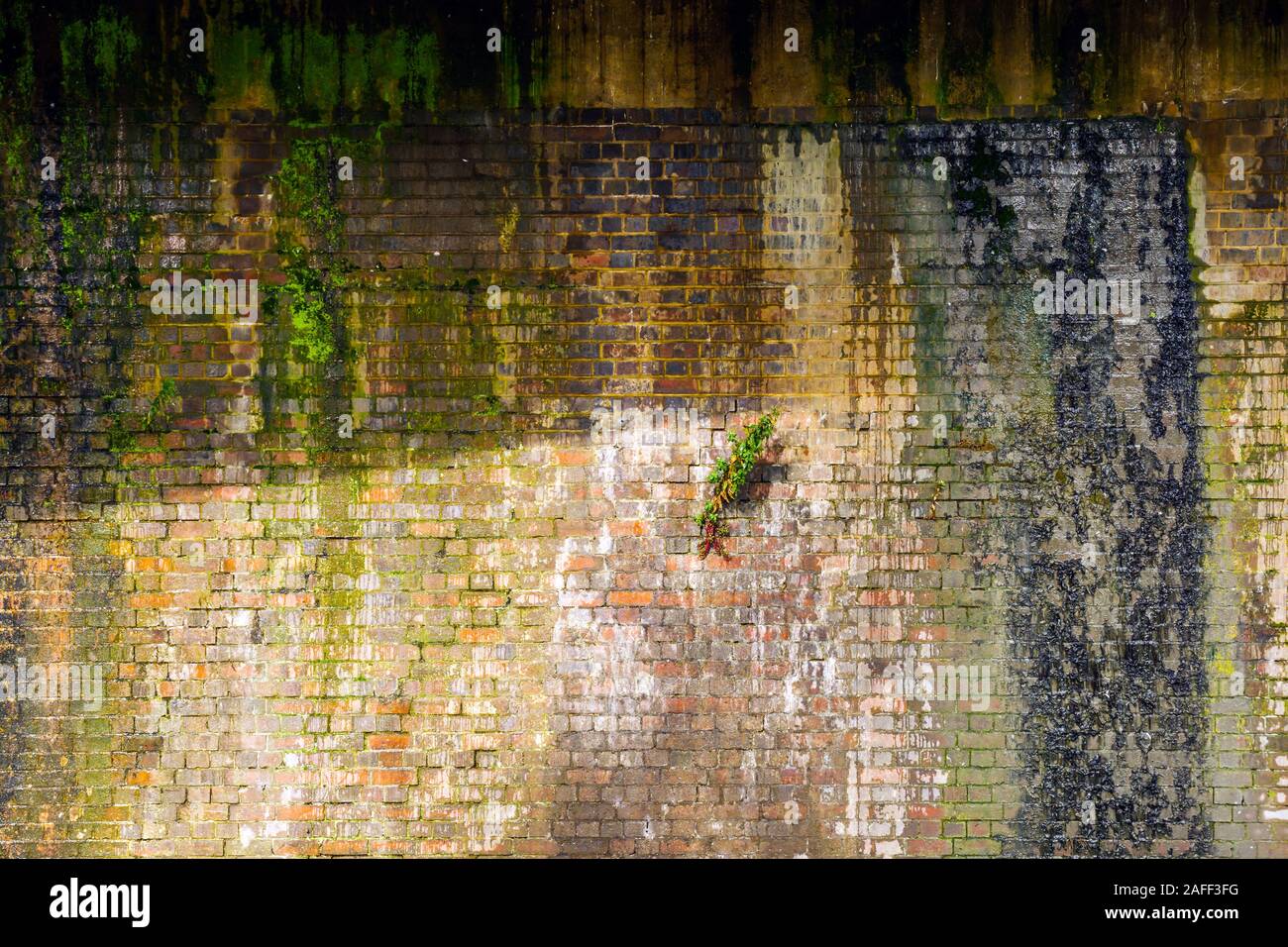 rusty brick wall under railway bridge in england uk Stock Photo - Alamy