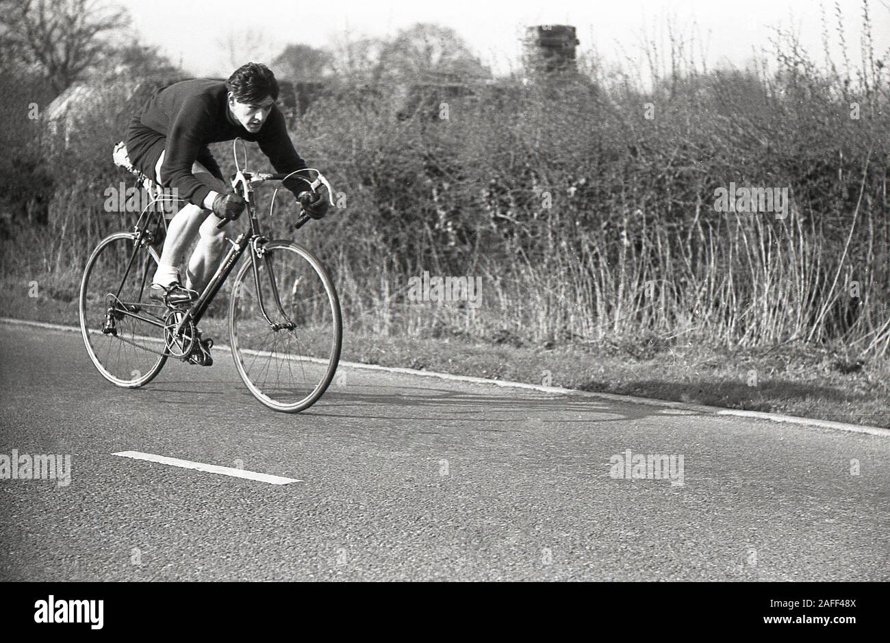 1950s, historical, a male cyclist out on a country road taking part in ...