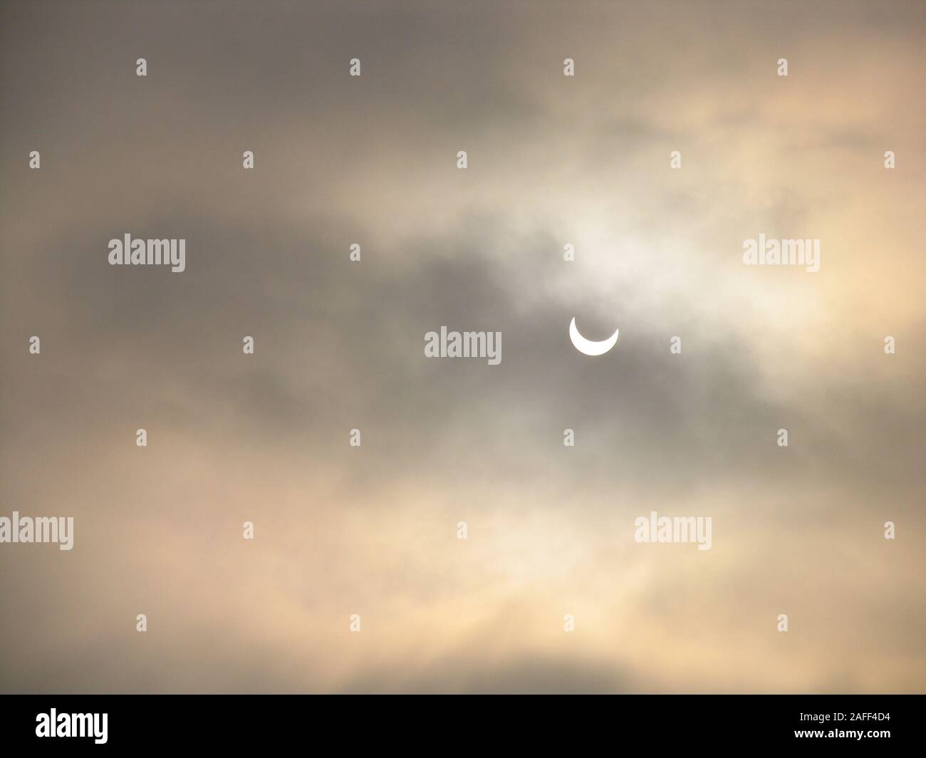sun covered with clouds during partial solar eclipse Stock Photo - Alamy