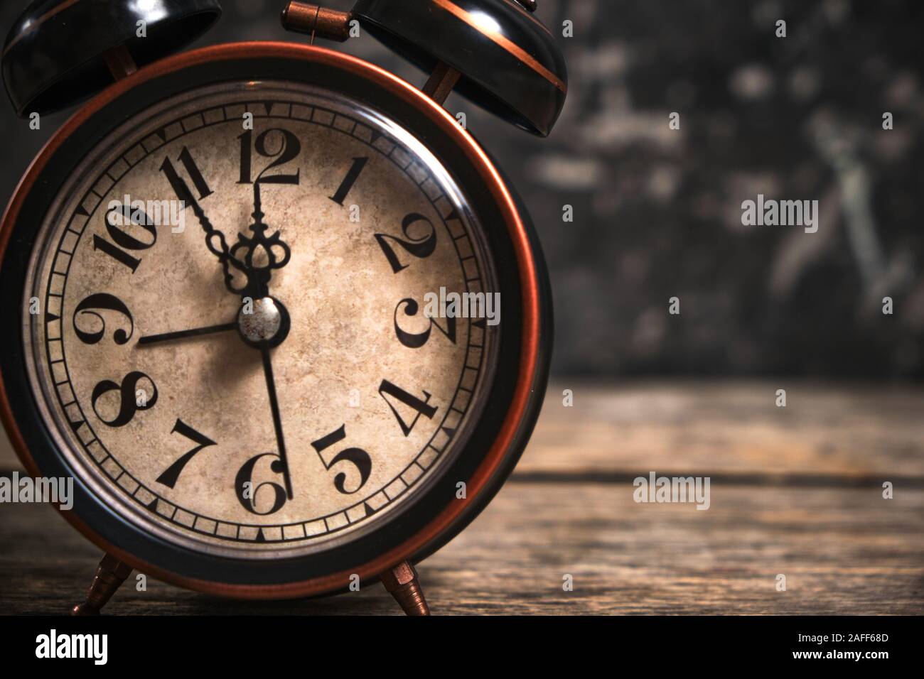 Old retro alarm clock on wooden table. Time is ticking and the hands ...