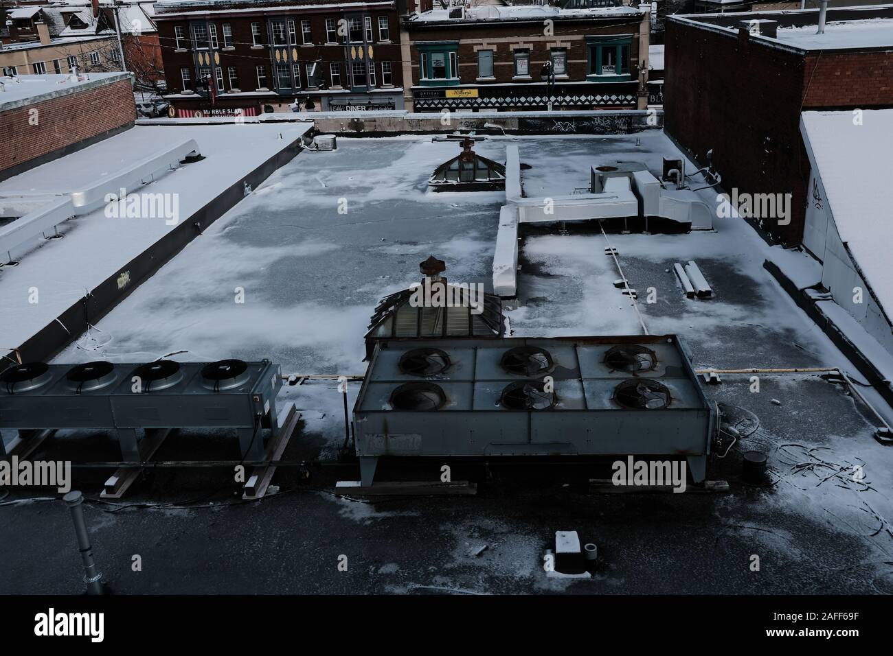 Snowy industrial rooftop showing heating and cooling units and ...