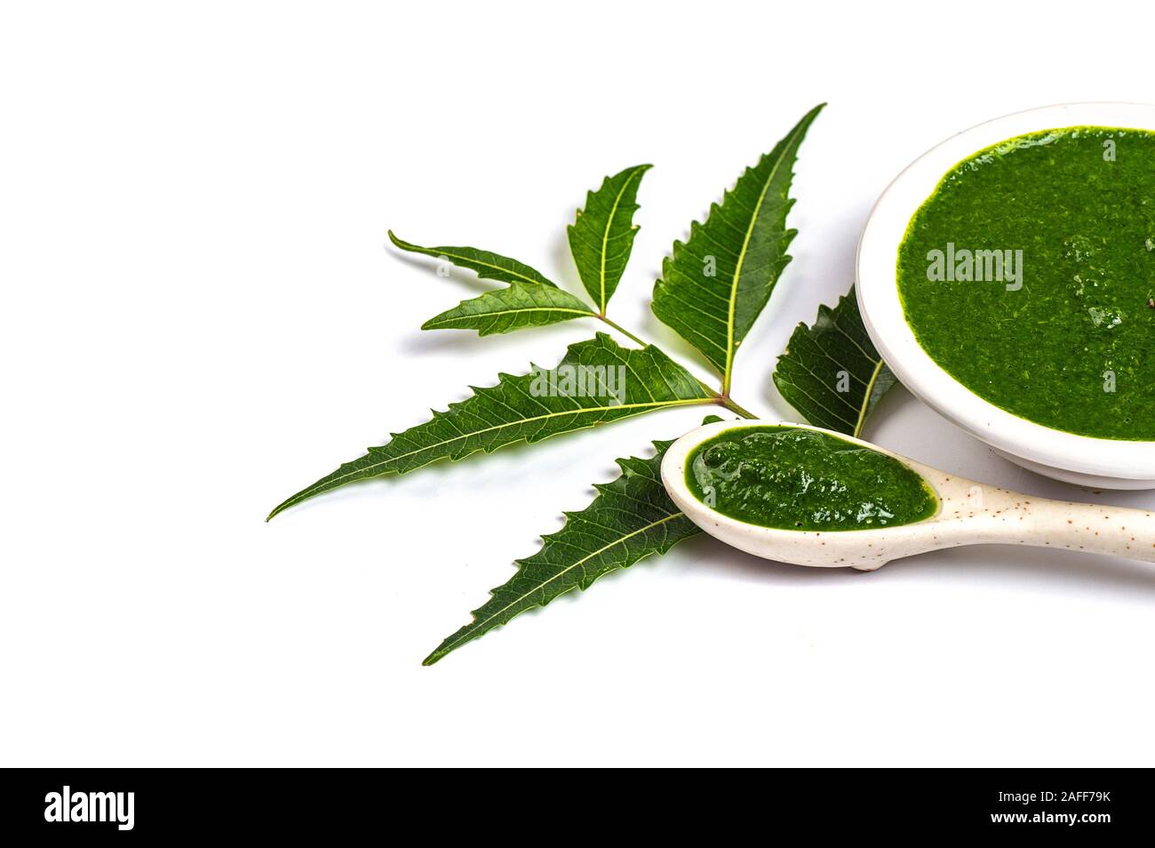 Medicinal Neem leaves with neem paste in spoon and plate on white ...