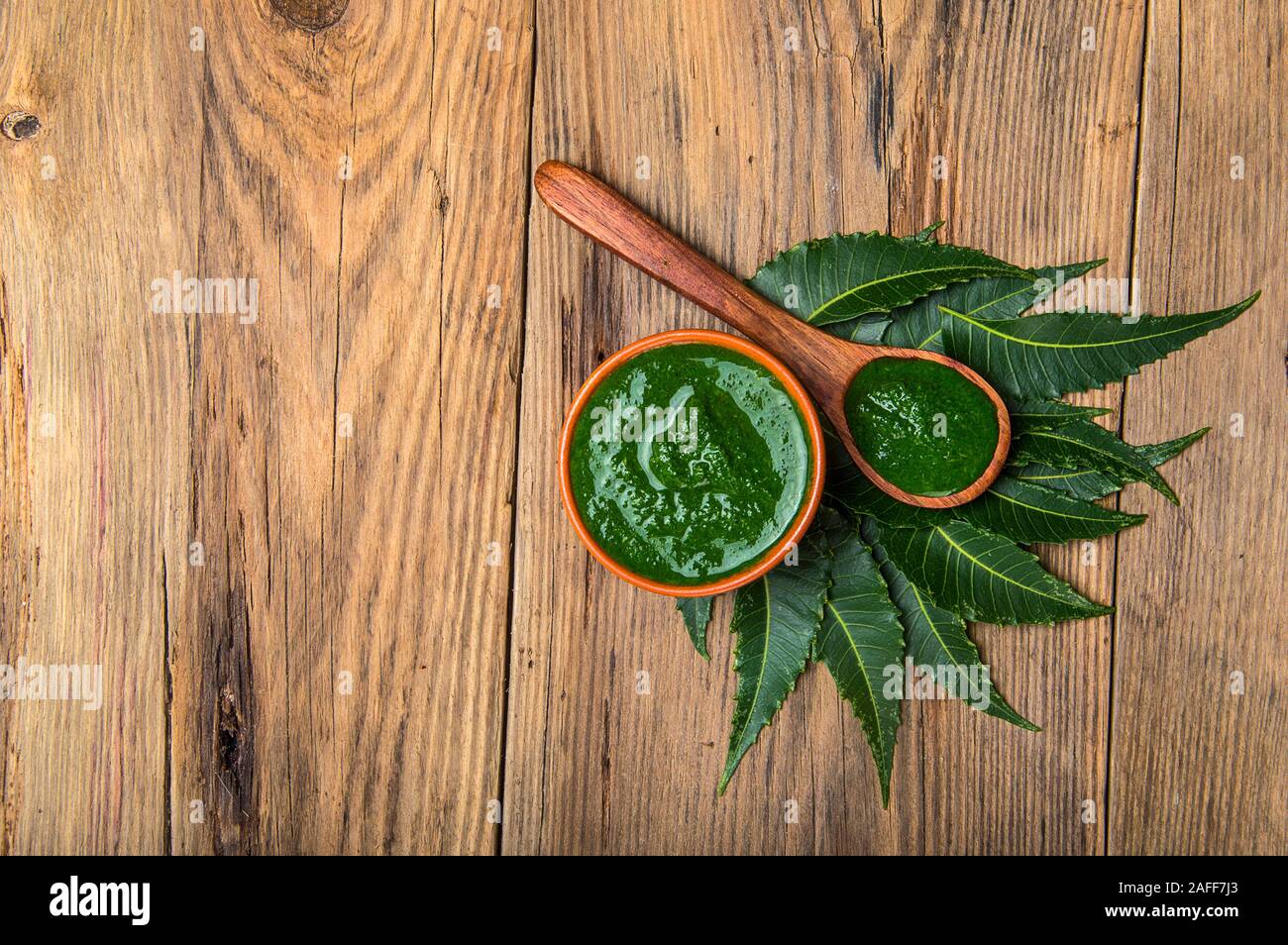 Medicinal Neem leaves with paste on wooden background Stock Photo - Alamy