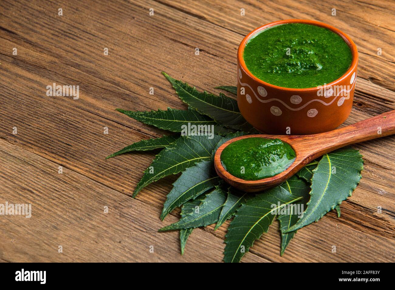 Medicinal Neem leaves with paste on wooden background Stock Photo - Alamy