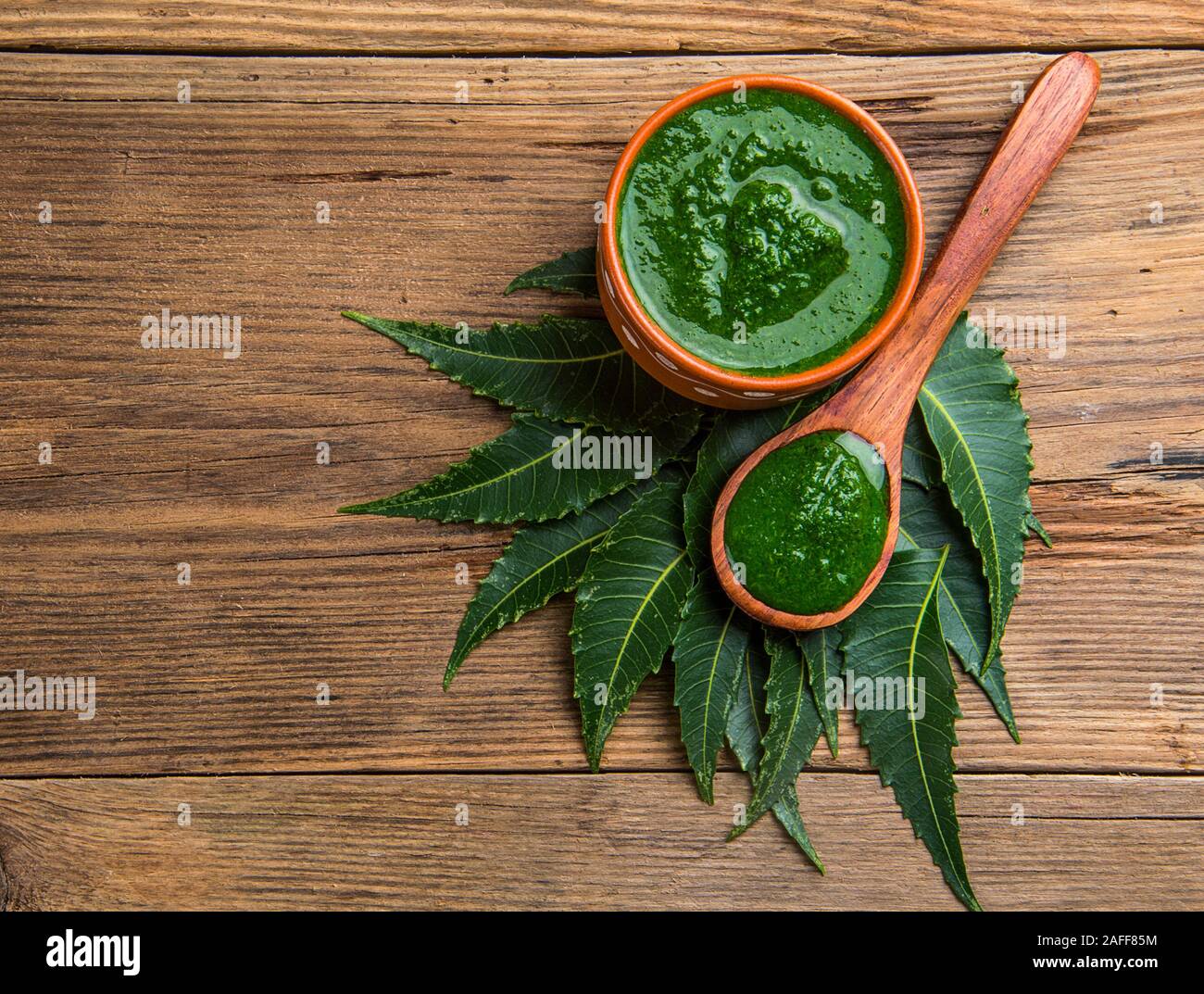 Medicinal Neem leaves with paste on wooden background Stock Photo - Alamy