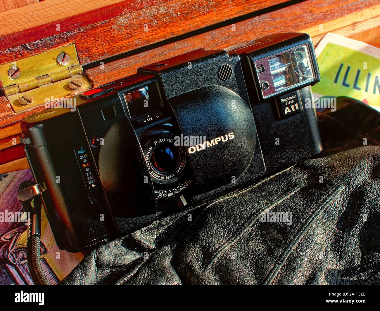 A retro film camera lays on leather gloves in a wooden footlocker. Car ...
