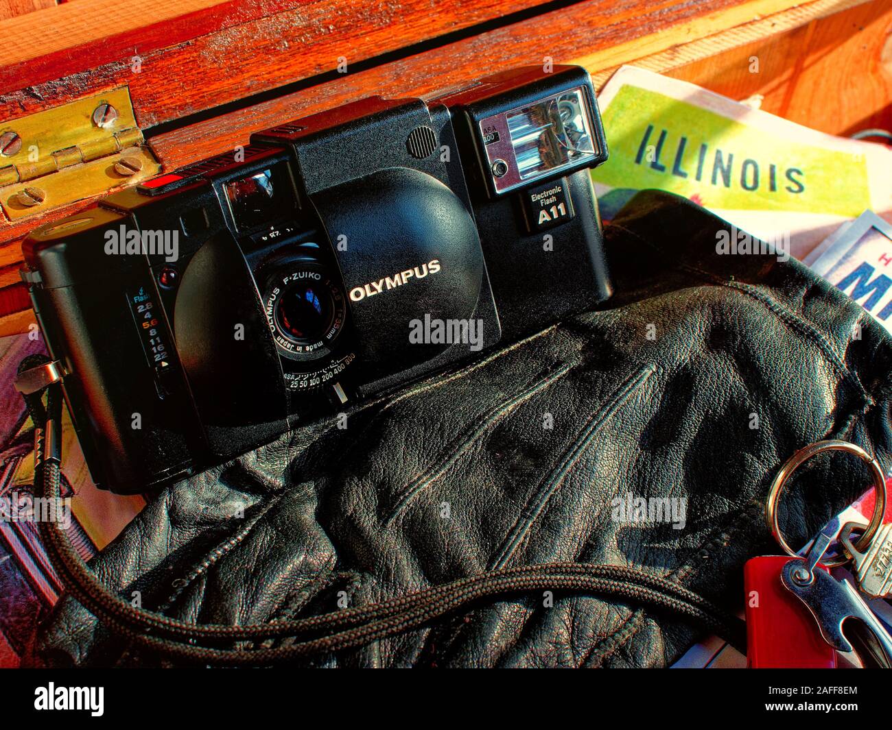 A retro film camera lays on leather gloves in a wooden footlocker. Car ...