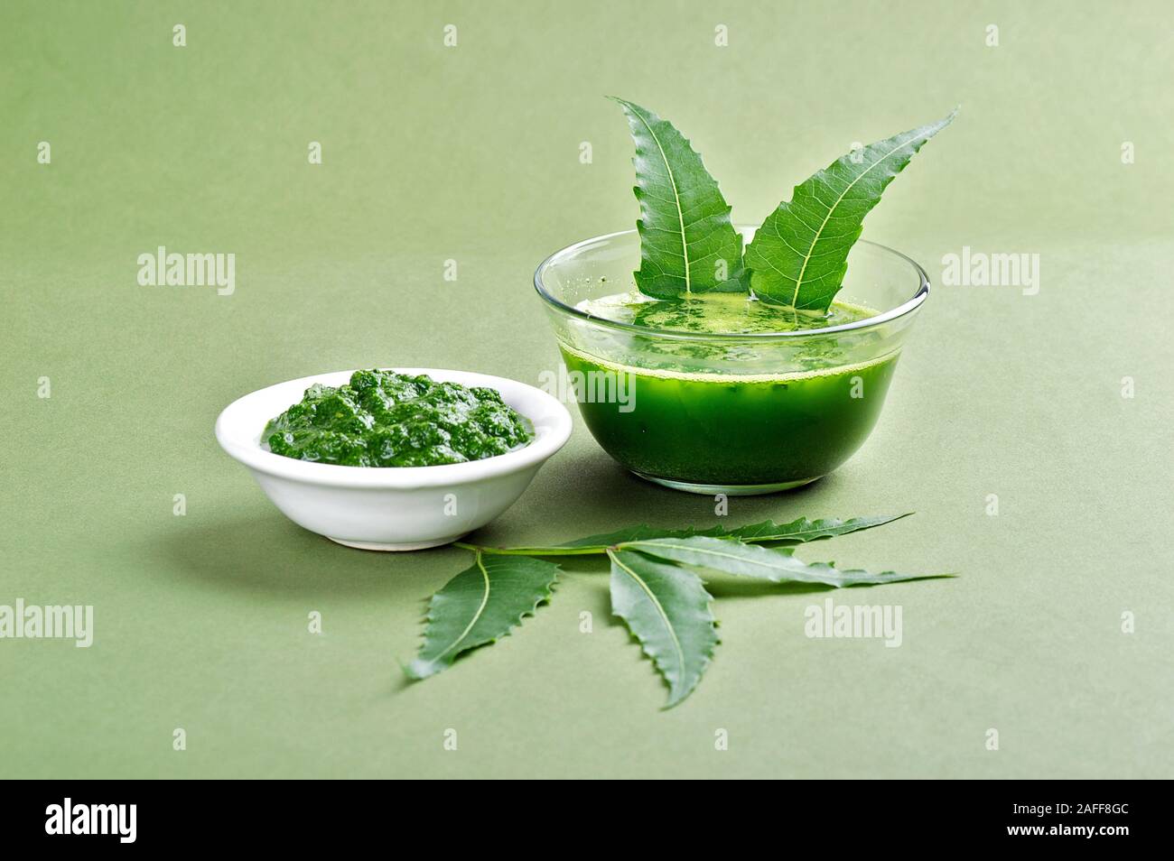 Medicinal Neem leaves paste and juice with leaves on green background ...