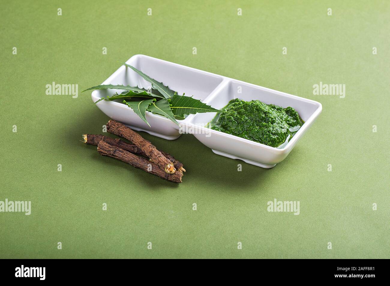 Medicinal Neem leaves paste and leaves with twigs on green background ...