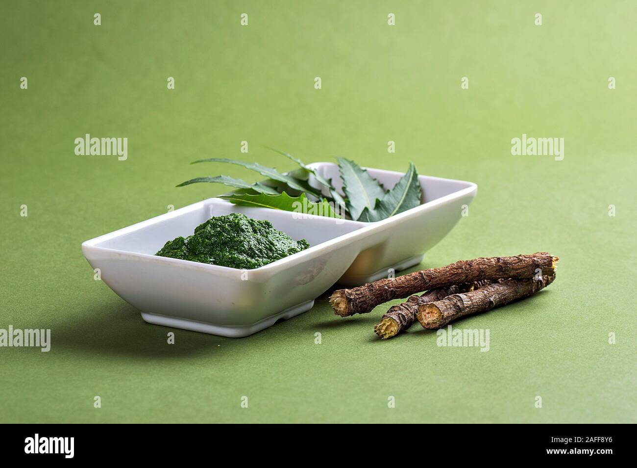 Medicinal Neem leaves paste and leaves with twigs on green background ...