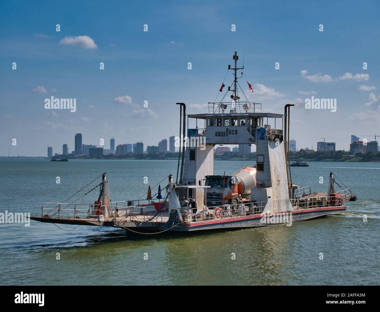 A ferry carrying a cement lorry crosses the Mekong River between Koh ...