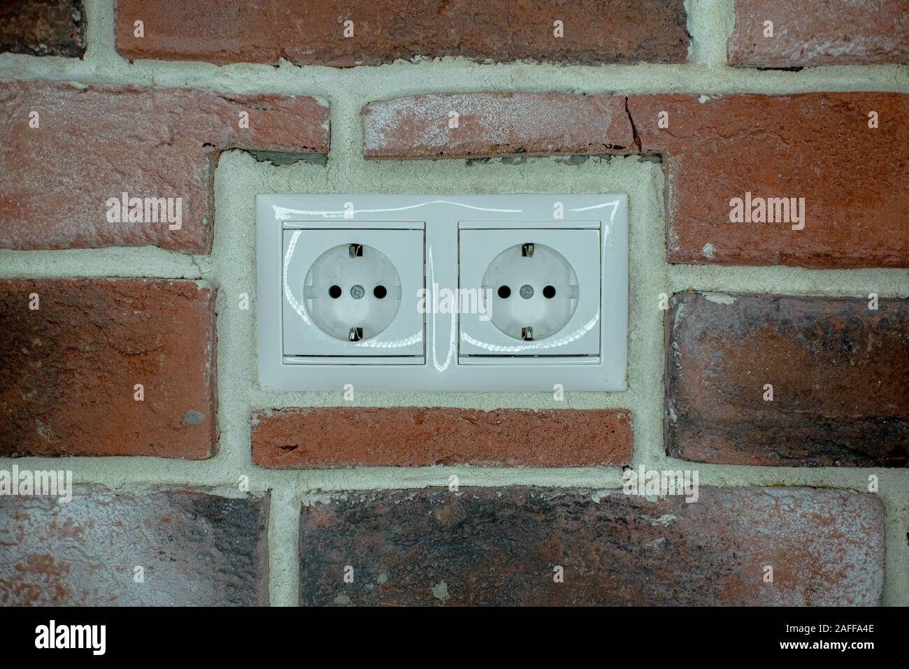 white double socket is built into the brick wall Stock Photo - Alamy