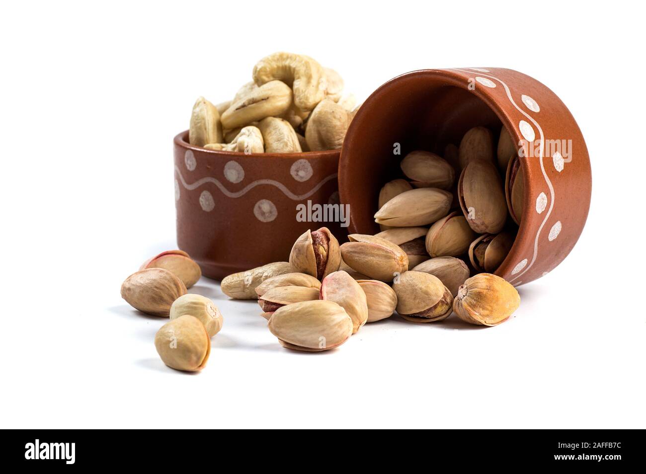 Pistachio and Cashew Nuts in clay pots on white background Stock Photo ...