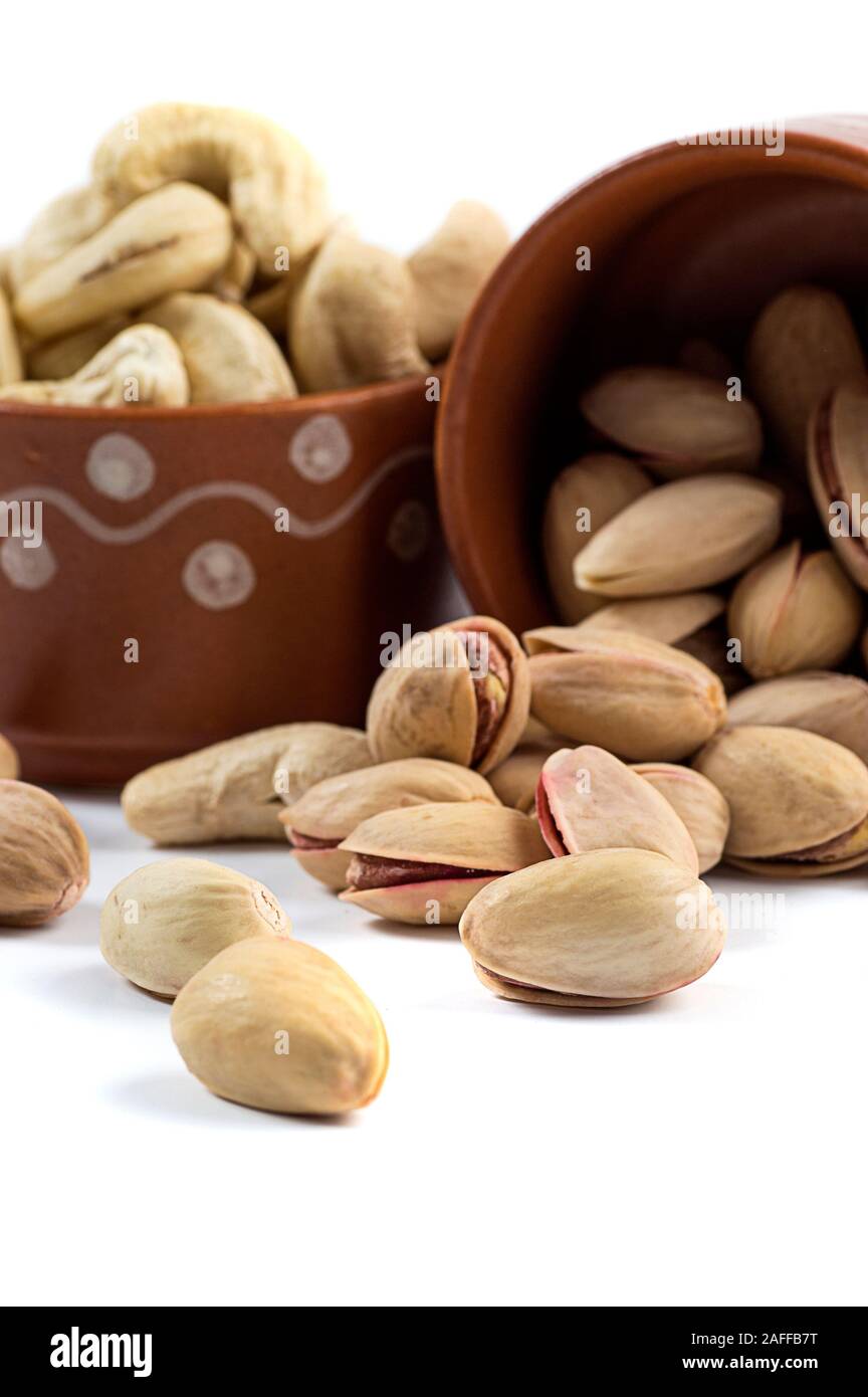 Pistachio and Cashew Nuts in clay pots on white background Stock Photo ...