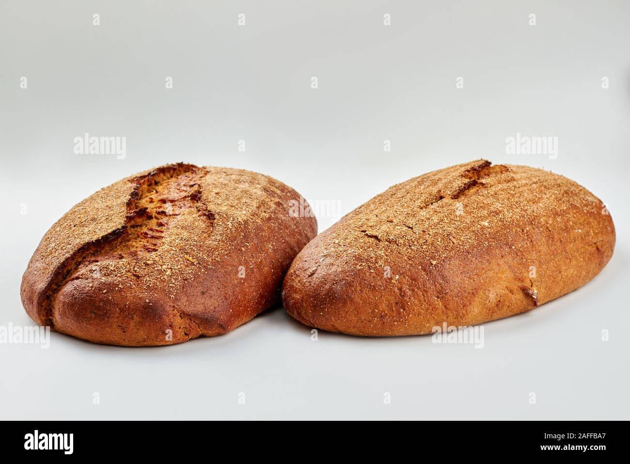 Two crusty loaves of bread on white background Stock Photo - Alamy