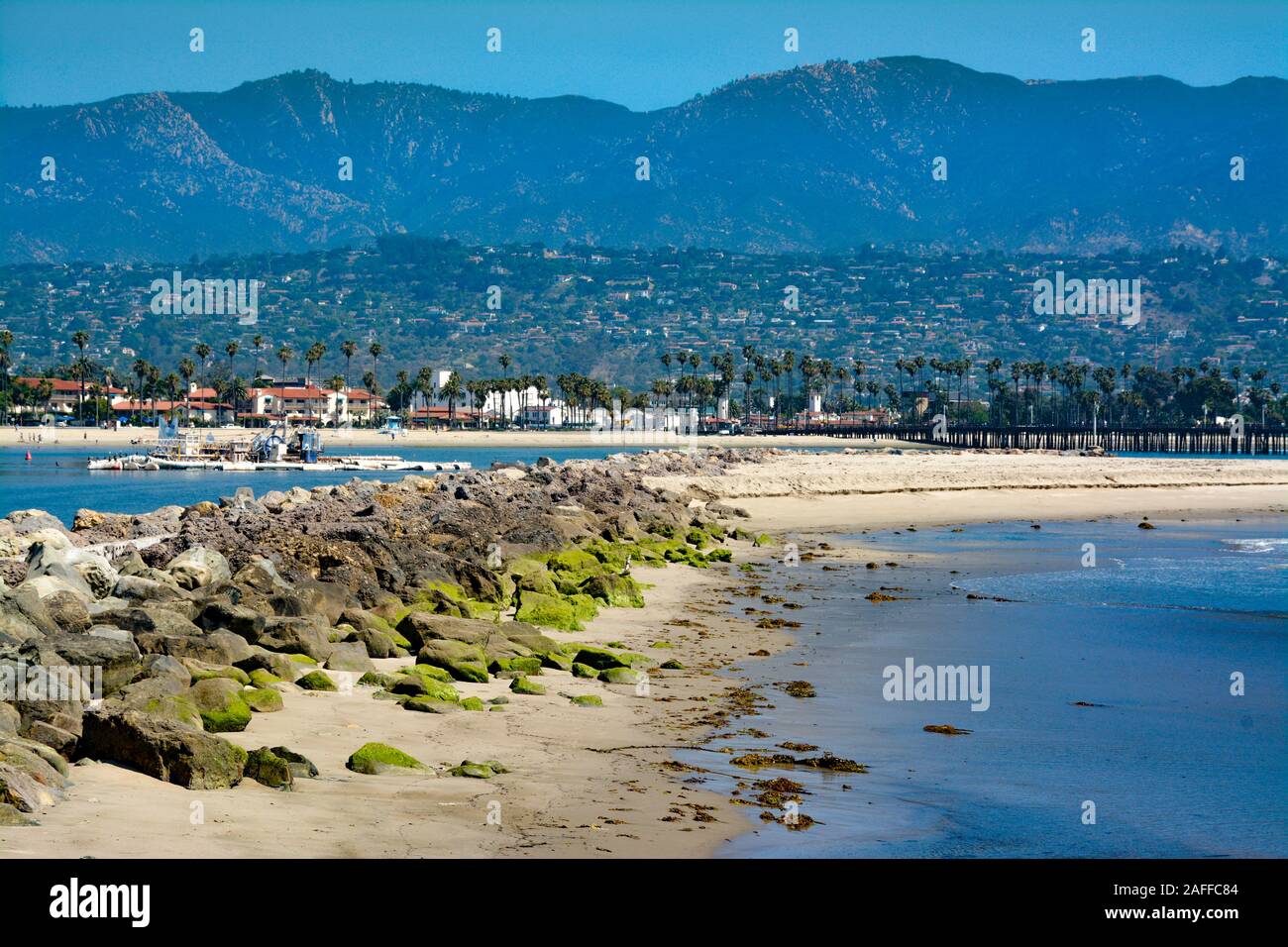 A sprawling view of the Santa Barbara harbor with rocky breakwater with ...