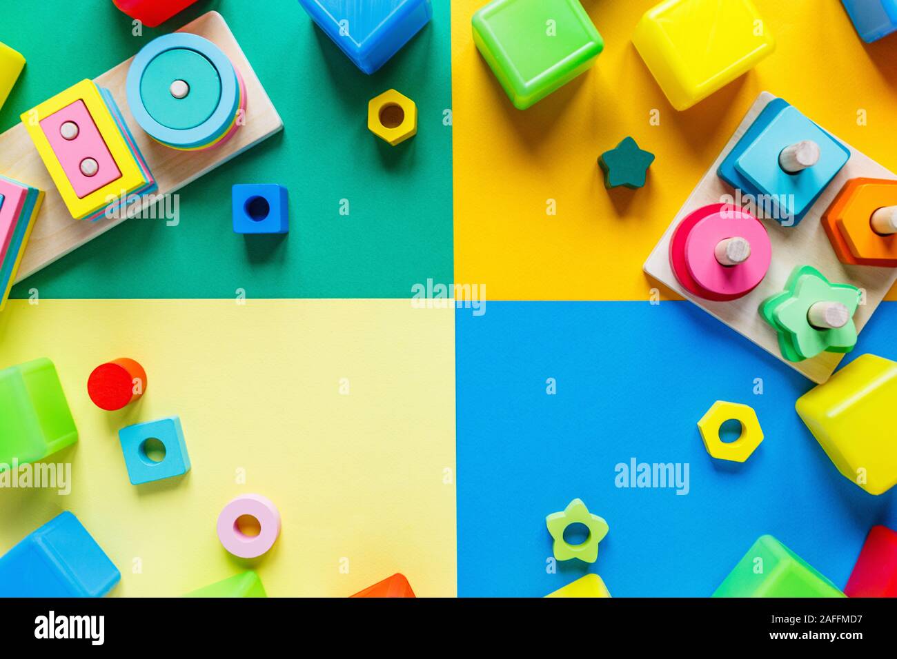 Wooden kids toys on colourful paper. Educational toys blocks, pyramid ...