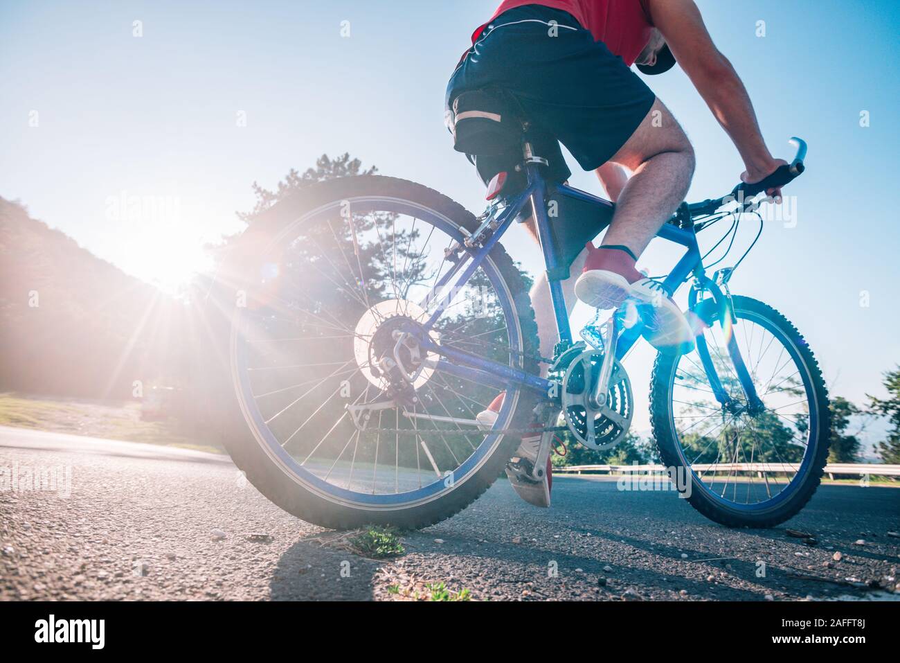Fit male biker cyclist riding his bike cycle on an asphalt road at ...