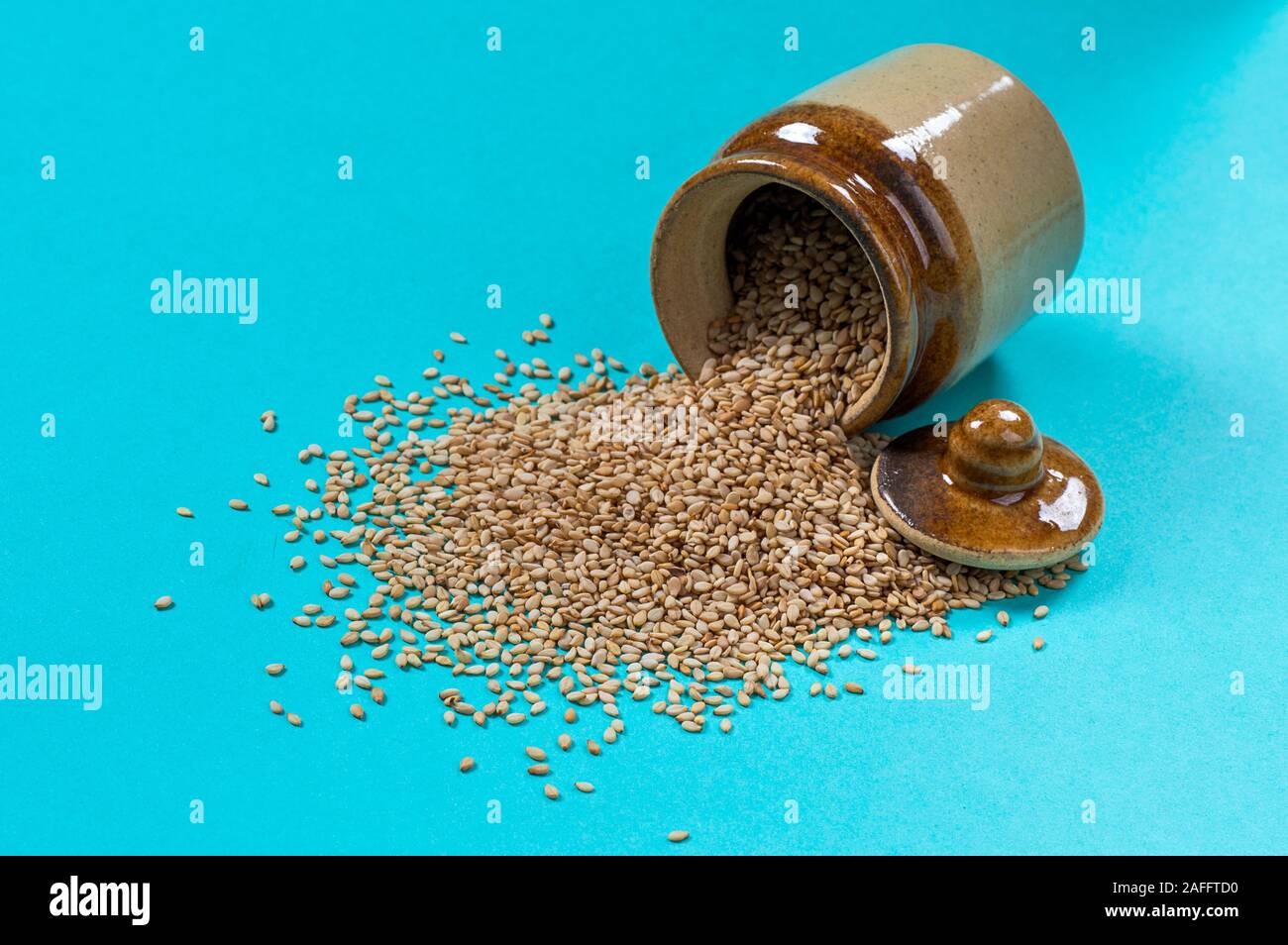 Sesame Seeds in pot on blue background Stock Photo - Alamy