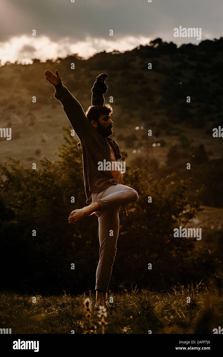 Stylish handsome young professional dancer man dancing on mountain ...