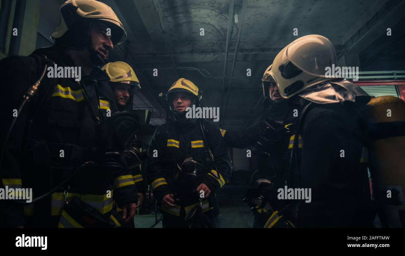 Team of firefighters standing inside ( indoors ) a buliding next to a ...