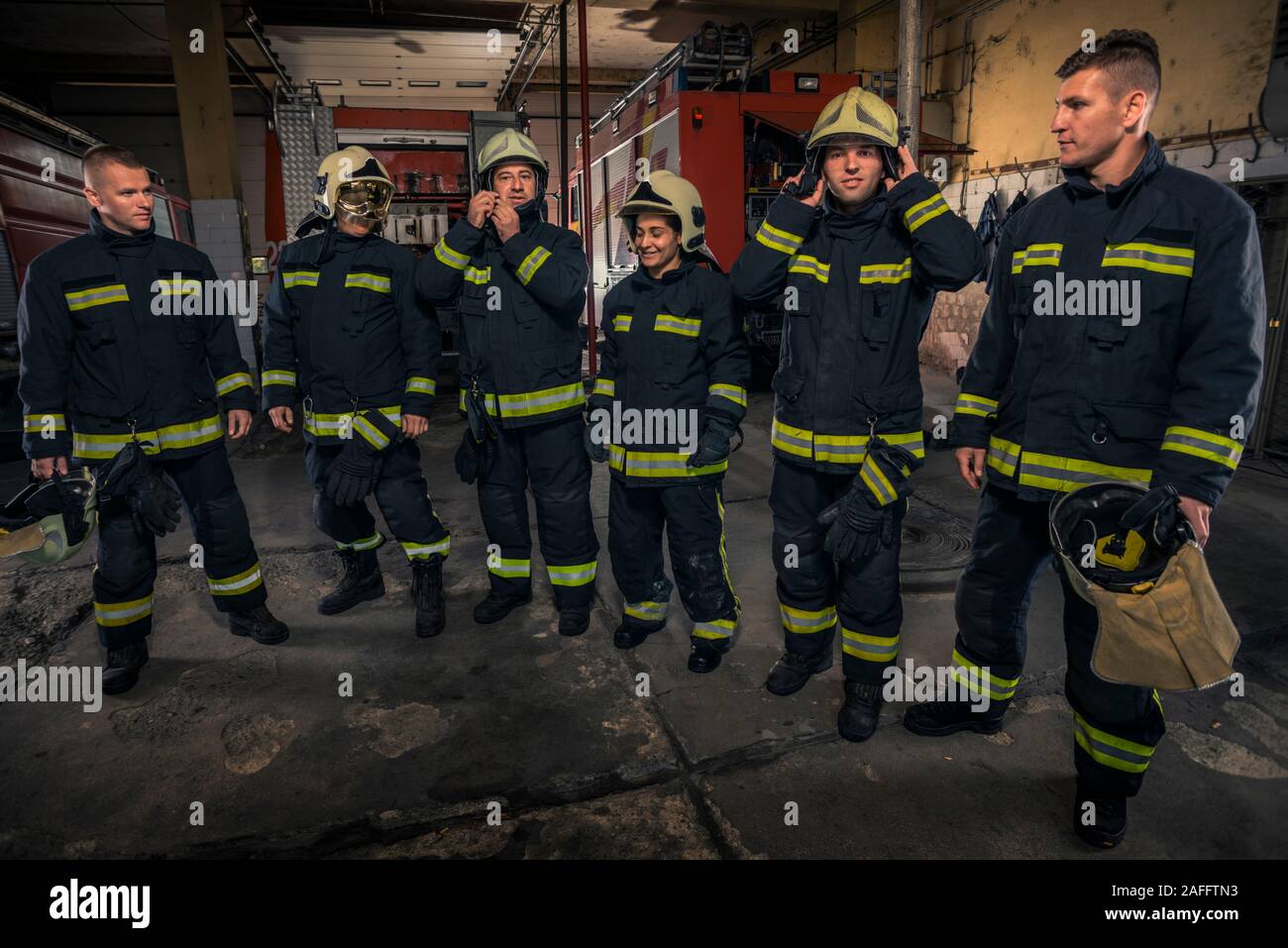 Portrait of firefighters standing by a fire engine Stock Photo - Alamy