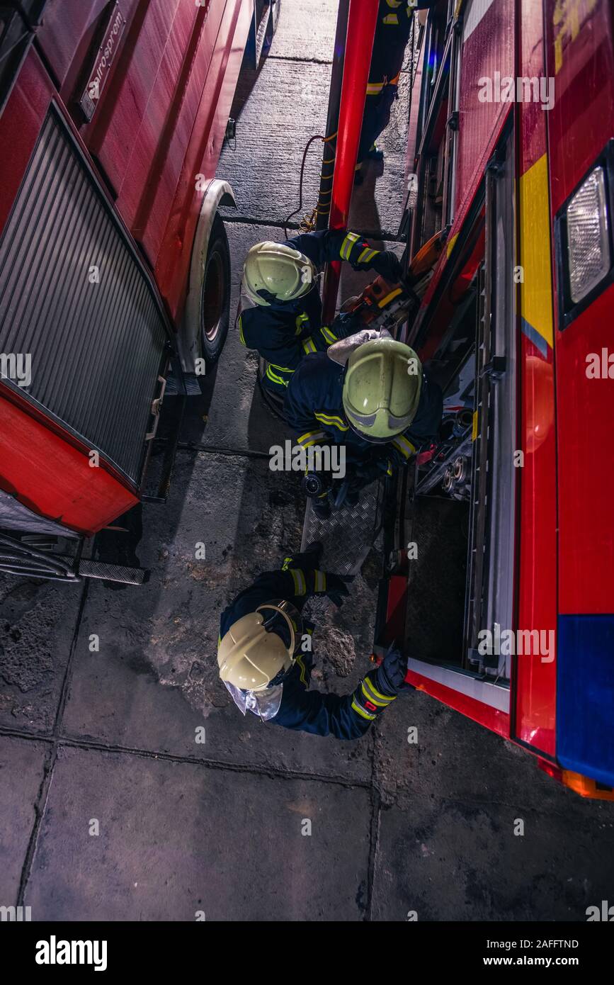 Firemen checking the fire engine inside the fire department from a bird ...