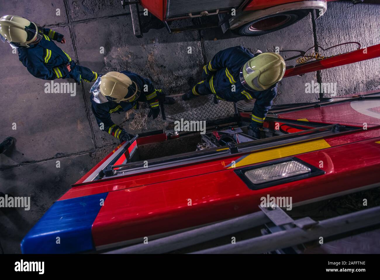 Firemen checking the fire engine inside the fire department from a bird ...