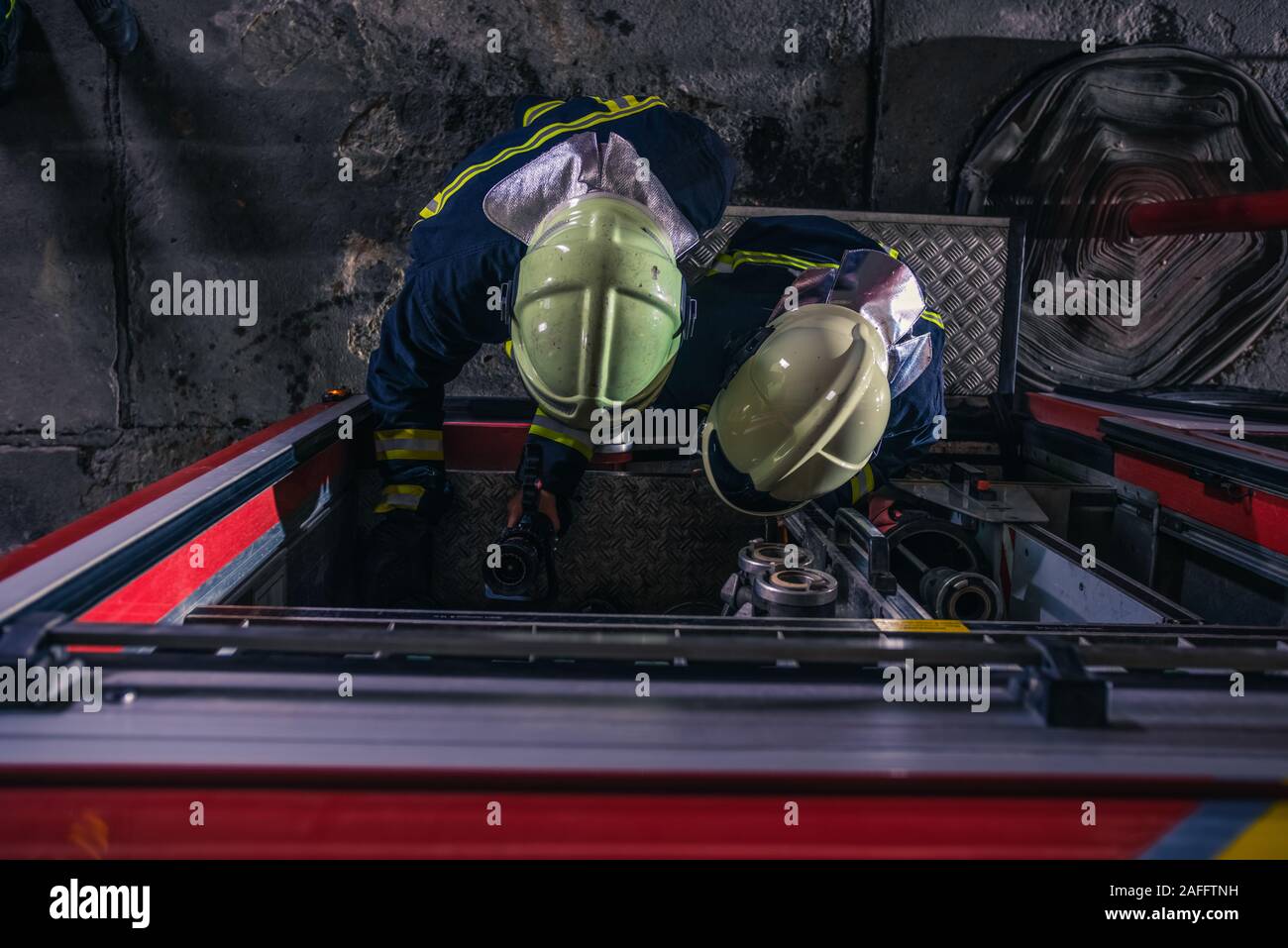 Firemen checking the fire engine inside the fire department from a bird ...